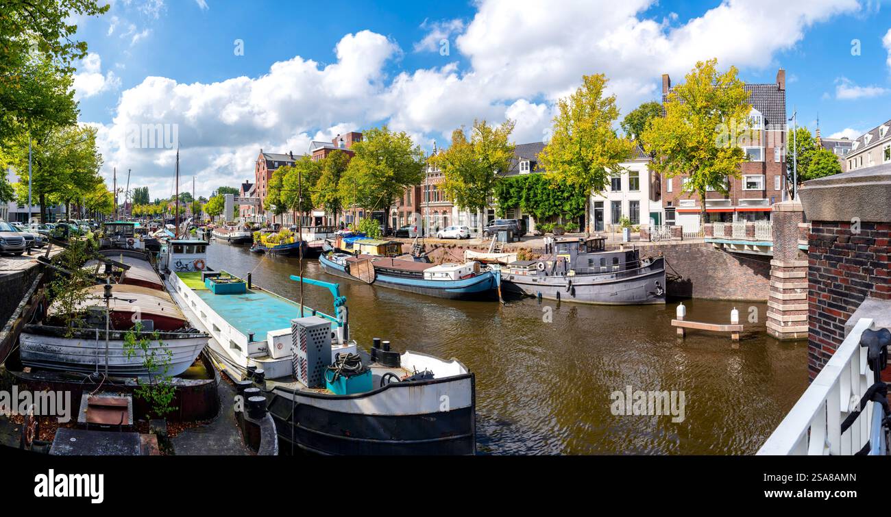 Cityscape with old, colourful boats along canal A in the historic city ...