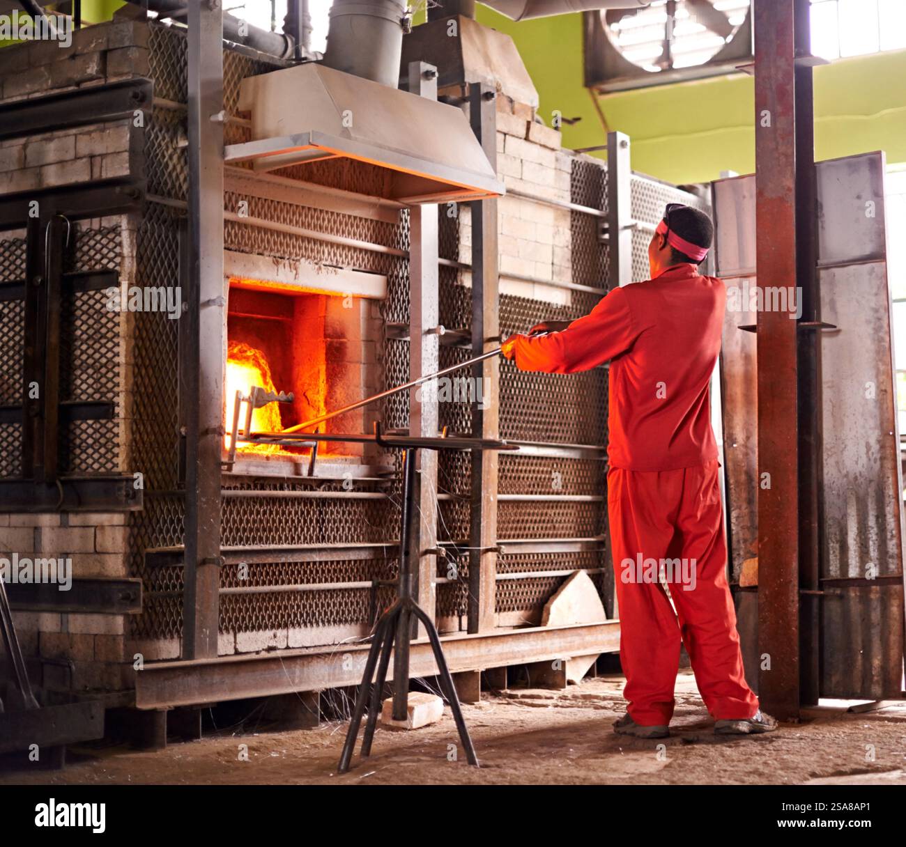 Glass factory, man and fire in furnace for production process ...