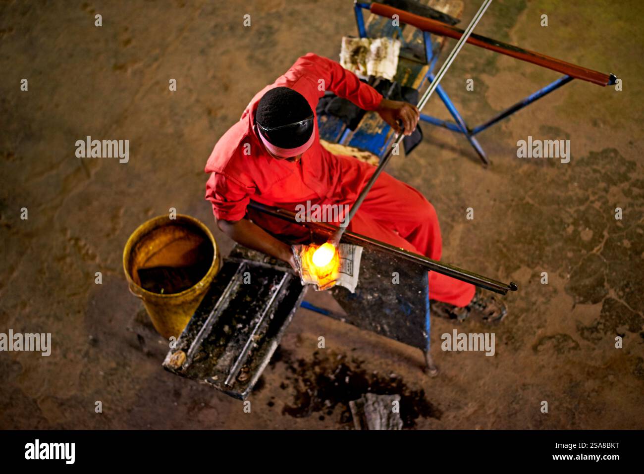 Above, glassblower and man with equipment, skills and heat with ...