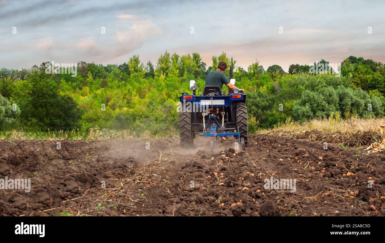 A farmer is plowing a field with his blue tractor, getting ready for ...