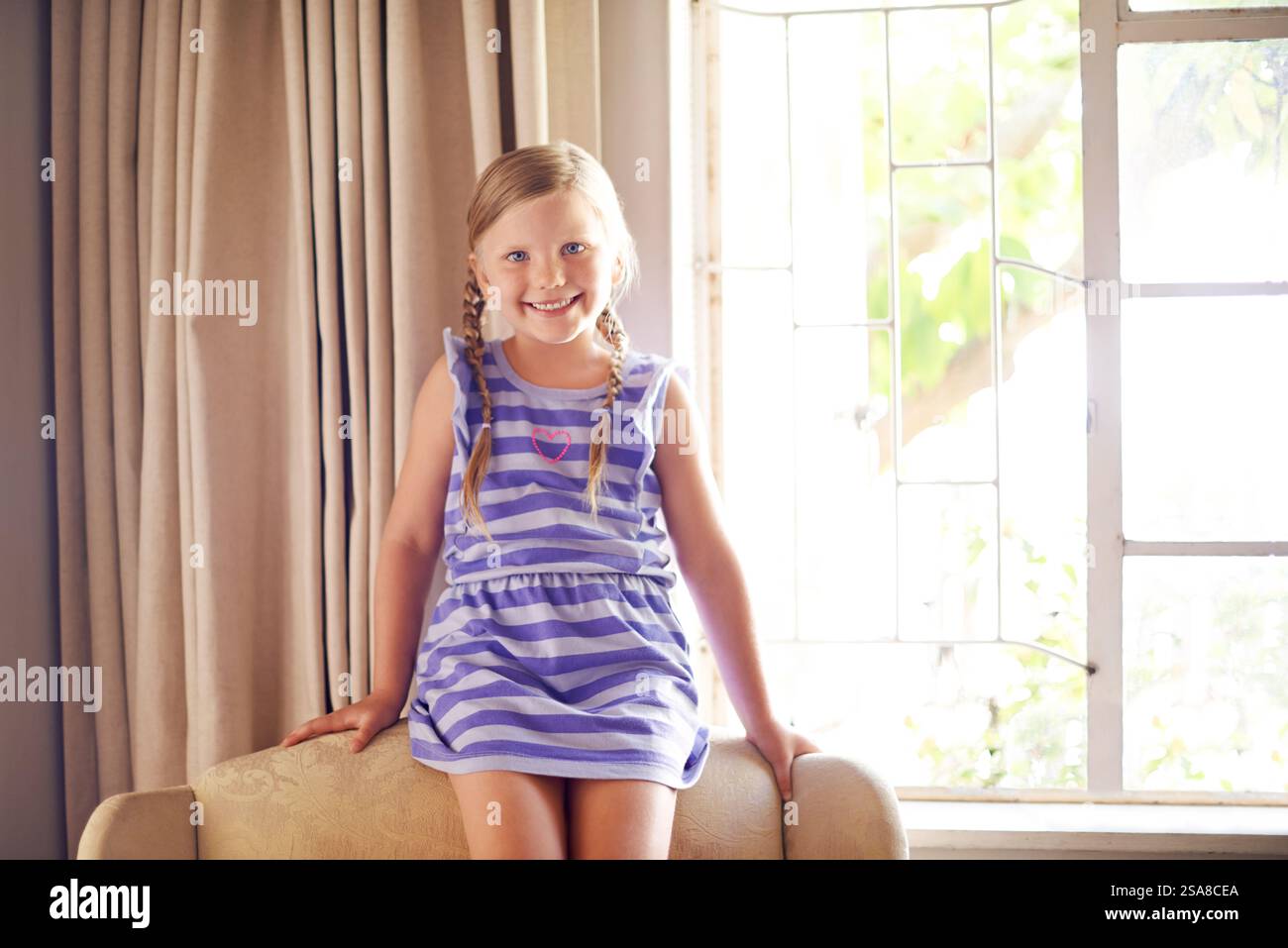 Portrait, smile and kid in home on sofa for relax, weekend and break in ...