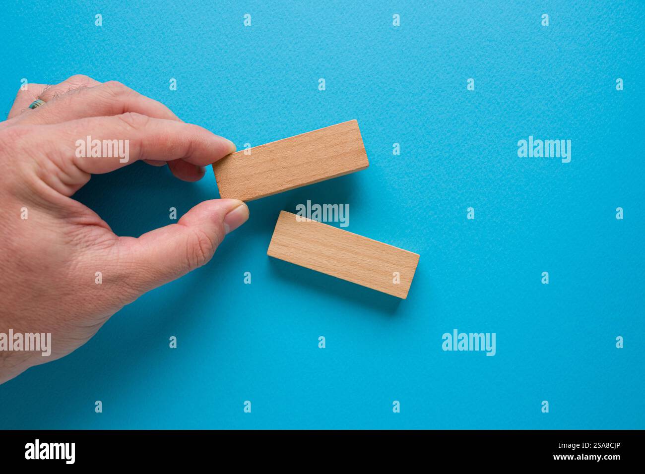 Blank wooden blocks and male hand on a blue background with space for ...