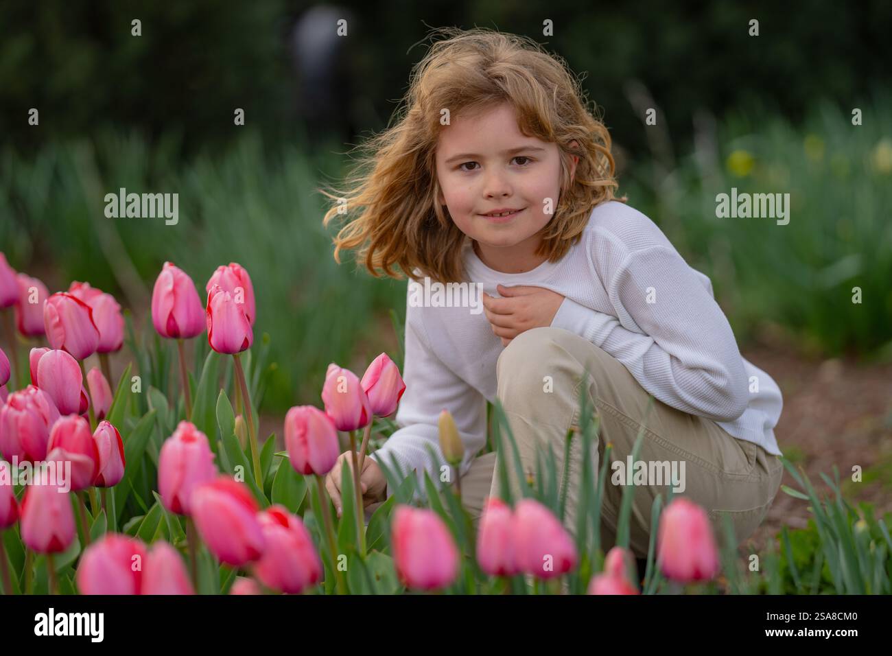 Tender Spring. Child play outdoors in a beautiful spring garden. Kid ...