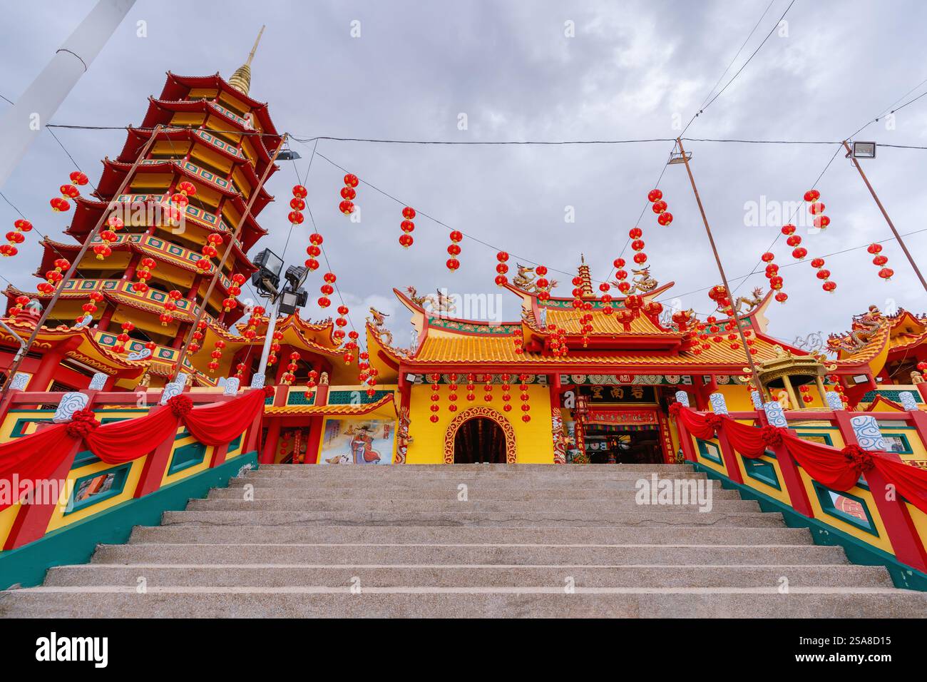 A grand staircase leads to a colorful temple with a pagoda and red ...
