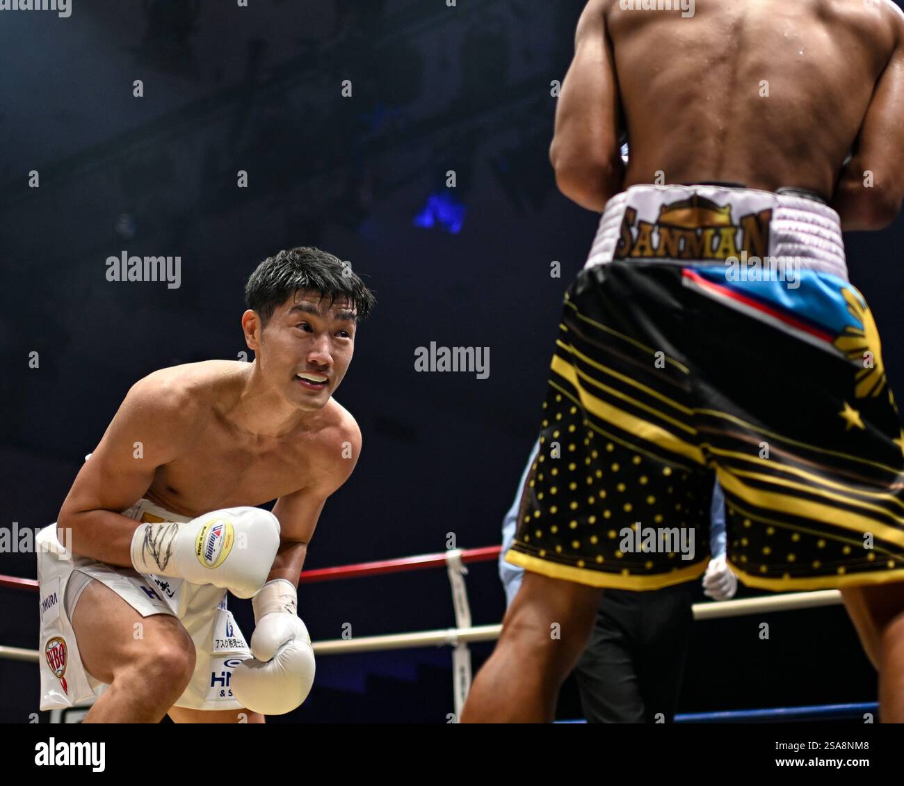 Champion Kenji Fujita (withe gloves) of Japan and challenger Michael Casama (blue gloves) of the ...