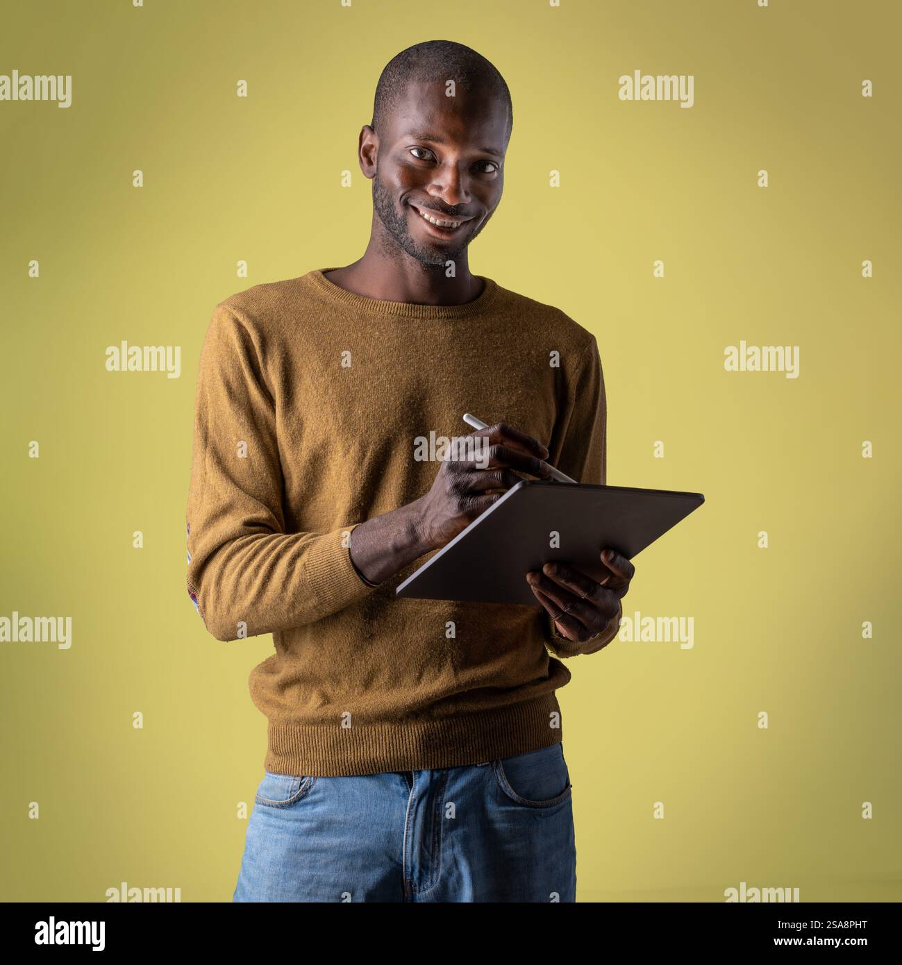 Smiling African man interacting with a digital tablet using a stylus ...