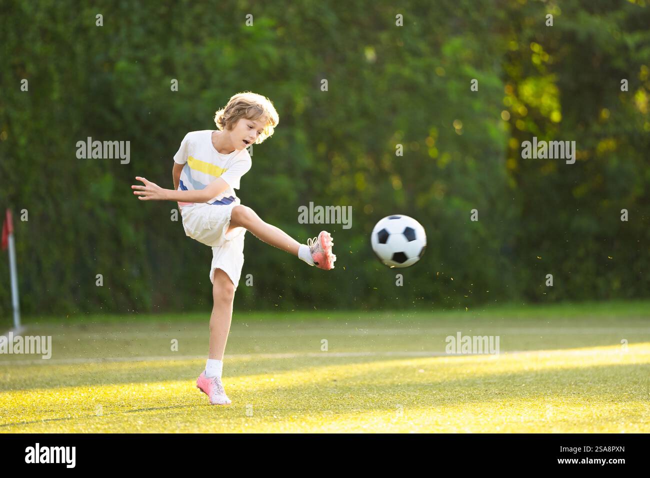 Child playing football. Kids play soccer on outdoor pitch. Little boy ...