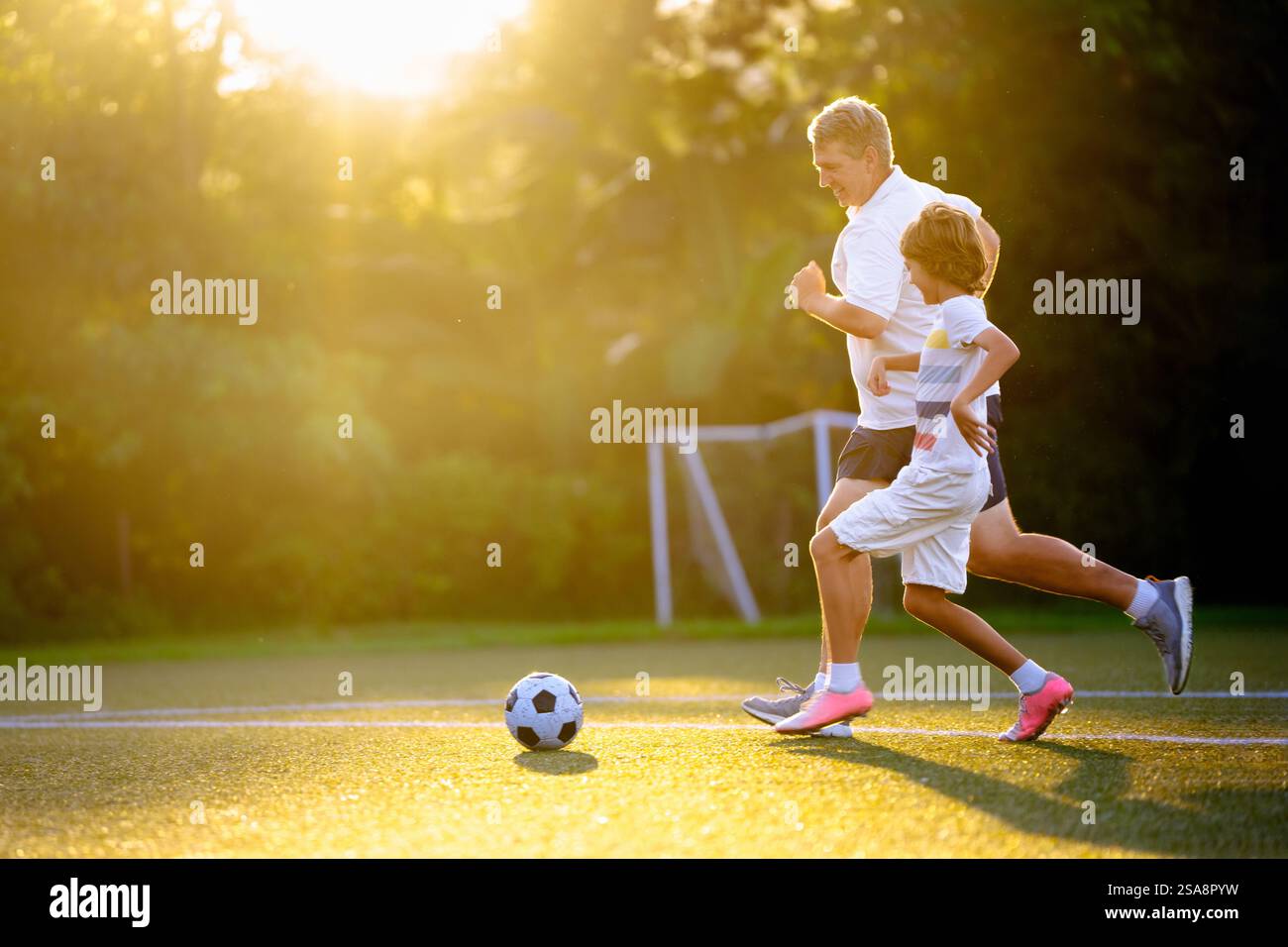 Child playing football. Kids play soccer on outdoor pitch. Little boy ...