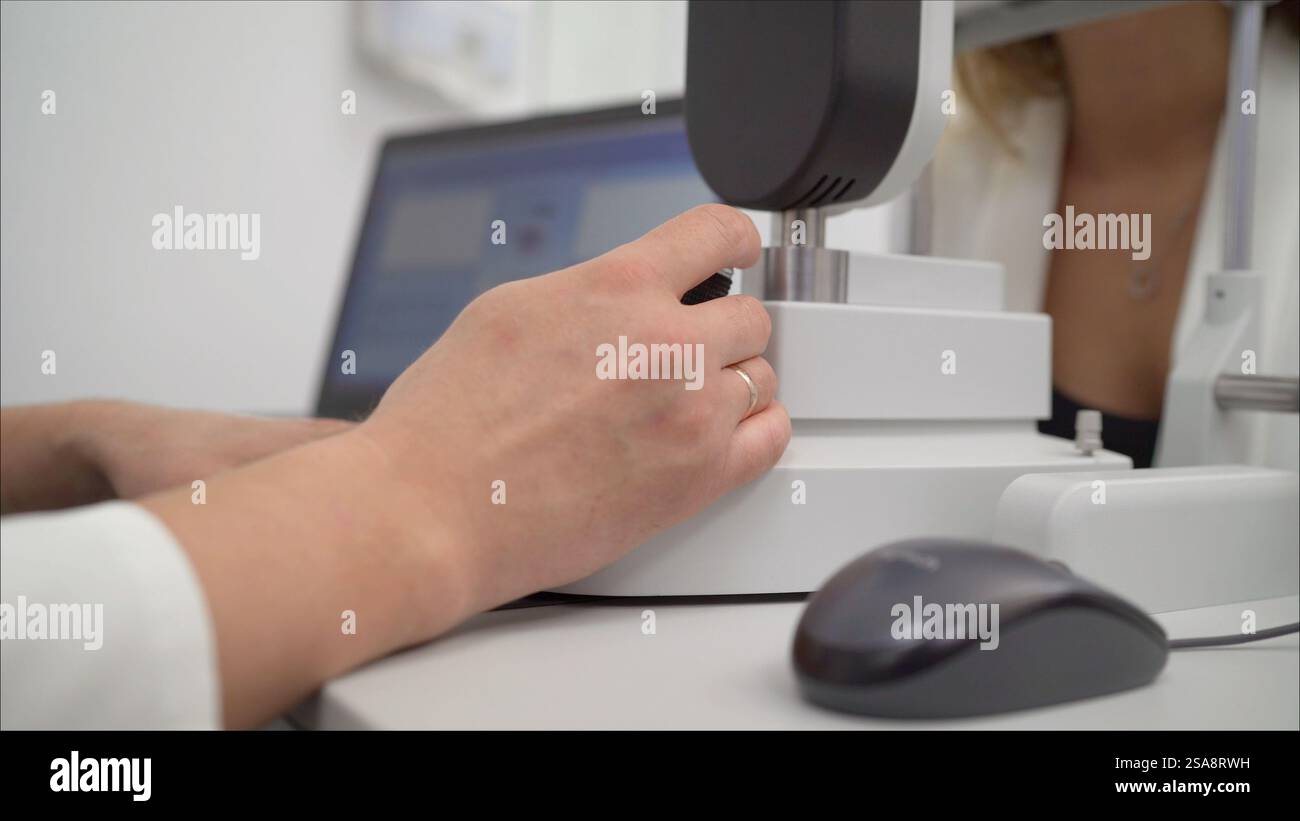 Doctor adjusting ophthalmic equipment during an eye exam in a modern ...