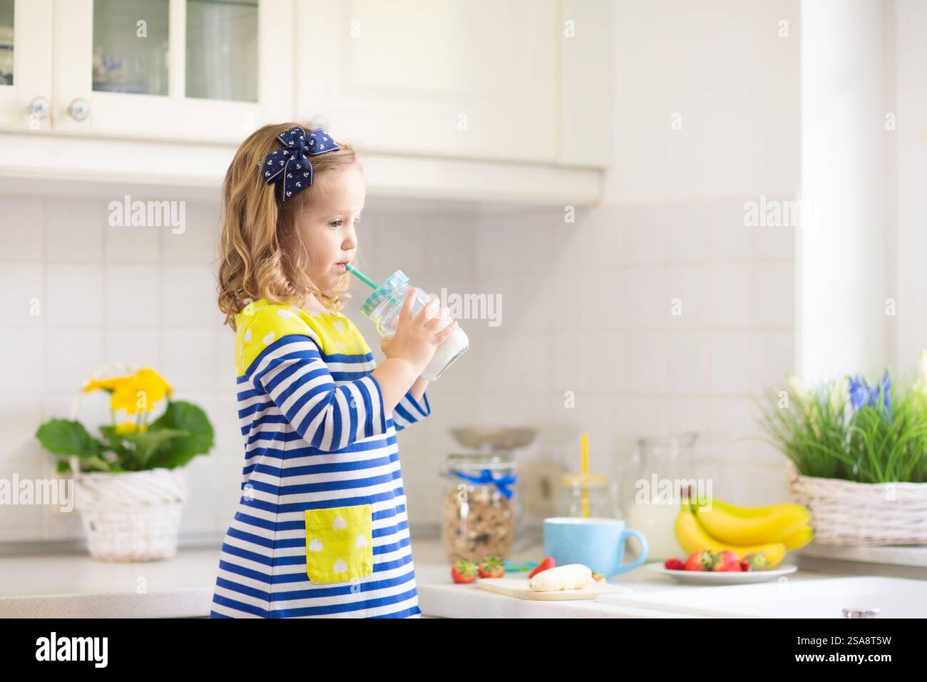 Kids eat breakfast in white kitchen. Healthy food for children. Child ...