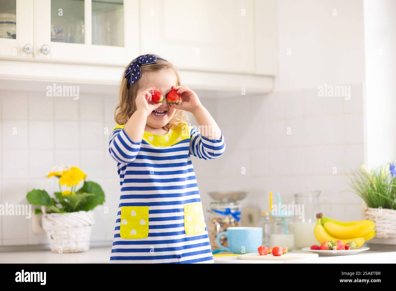 Kids eat breakfast in white kitchen. Healthy food for children. Child ...