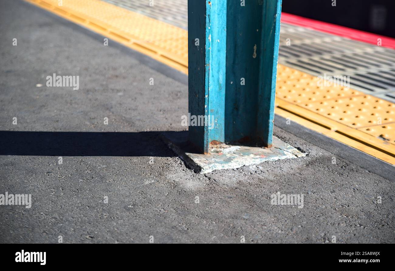The base of a weathered blue support beam near the edge of a train ...