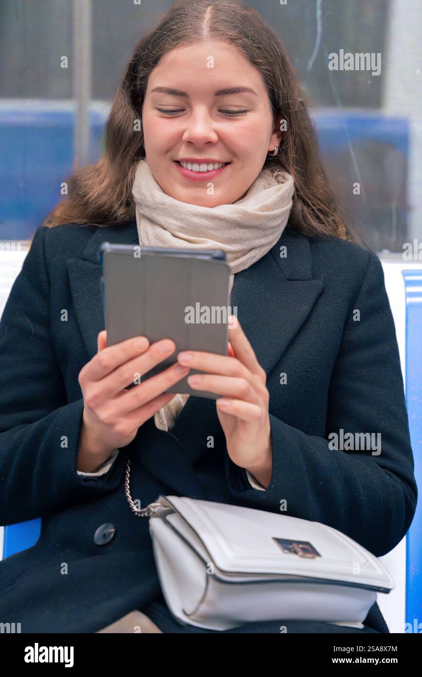 Young Woman Reading on E-Reader While Commuting on Subway Train ...