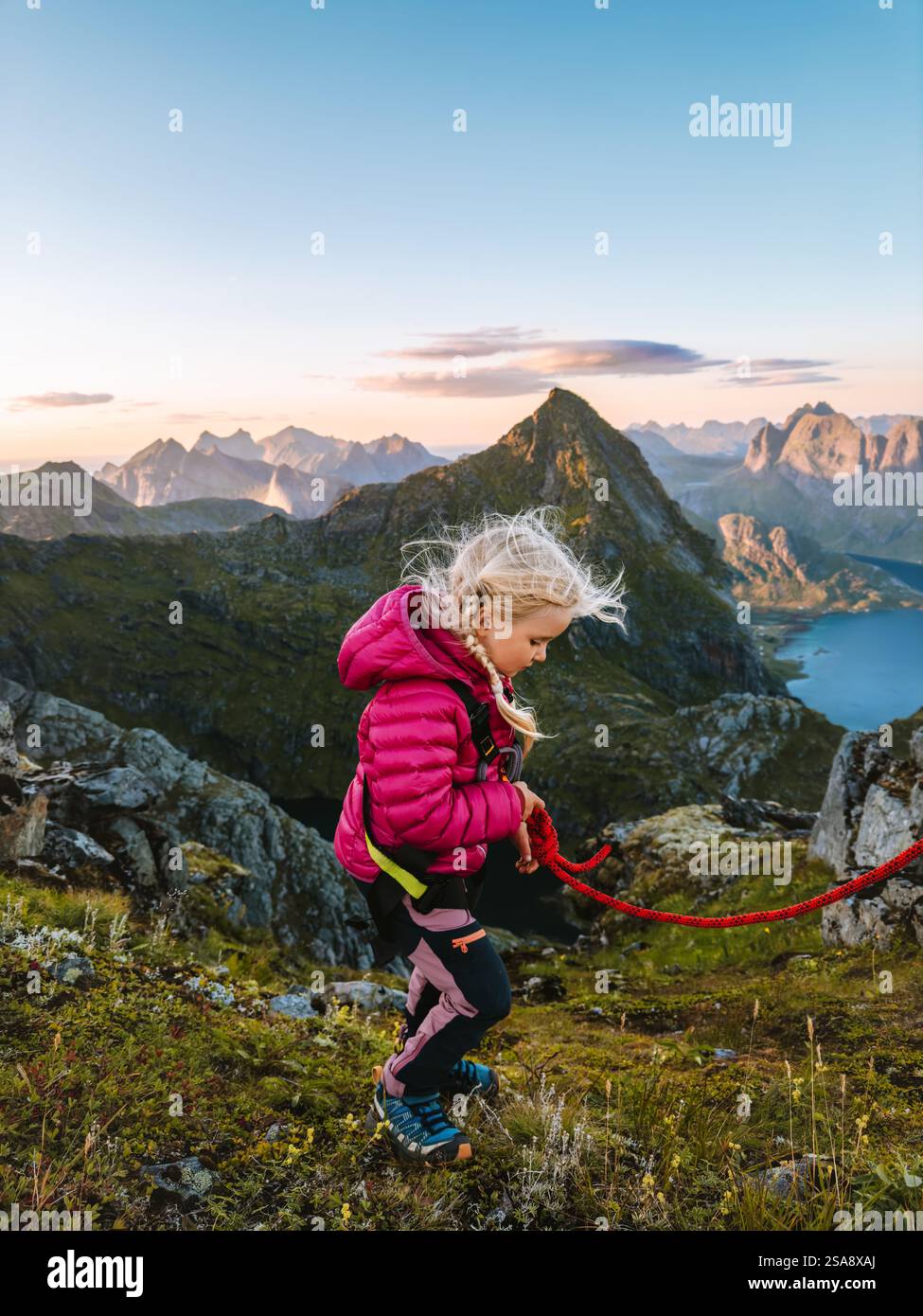 Child girl with climbing gear hiking in mountains of Norway, kid using ...