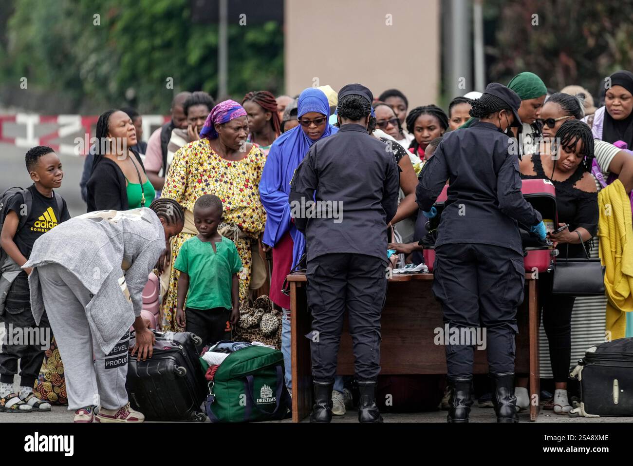 Rwanda security officials check people crossing from Congo in Gisenyi, Rwanda, Wednesday, Jan ...