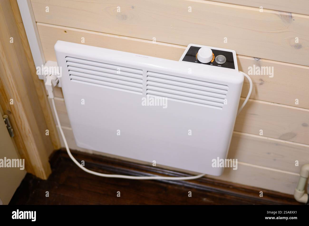 White modern smart convector heater connected to an outlet on the wall ...
