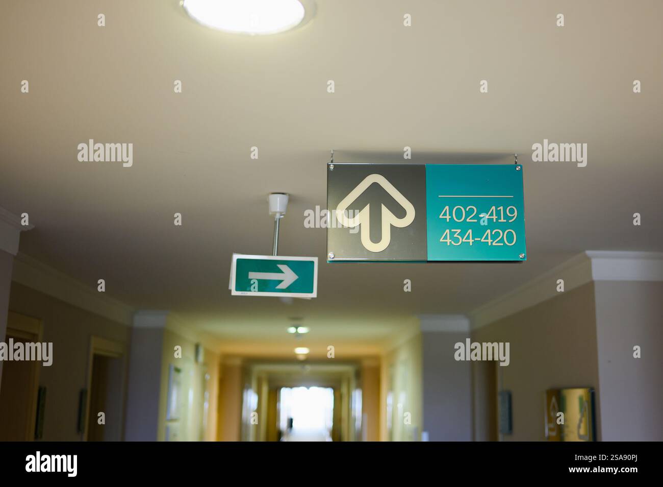 Hotel room sign on hotel ceiling and emergency exit sign. Room numbers ...