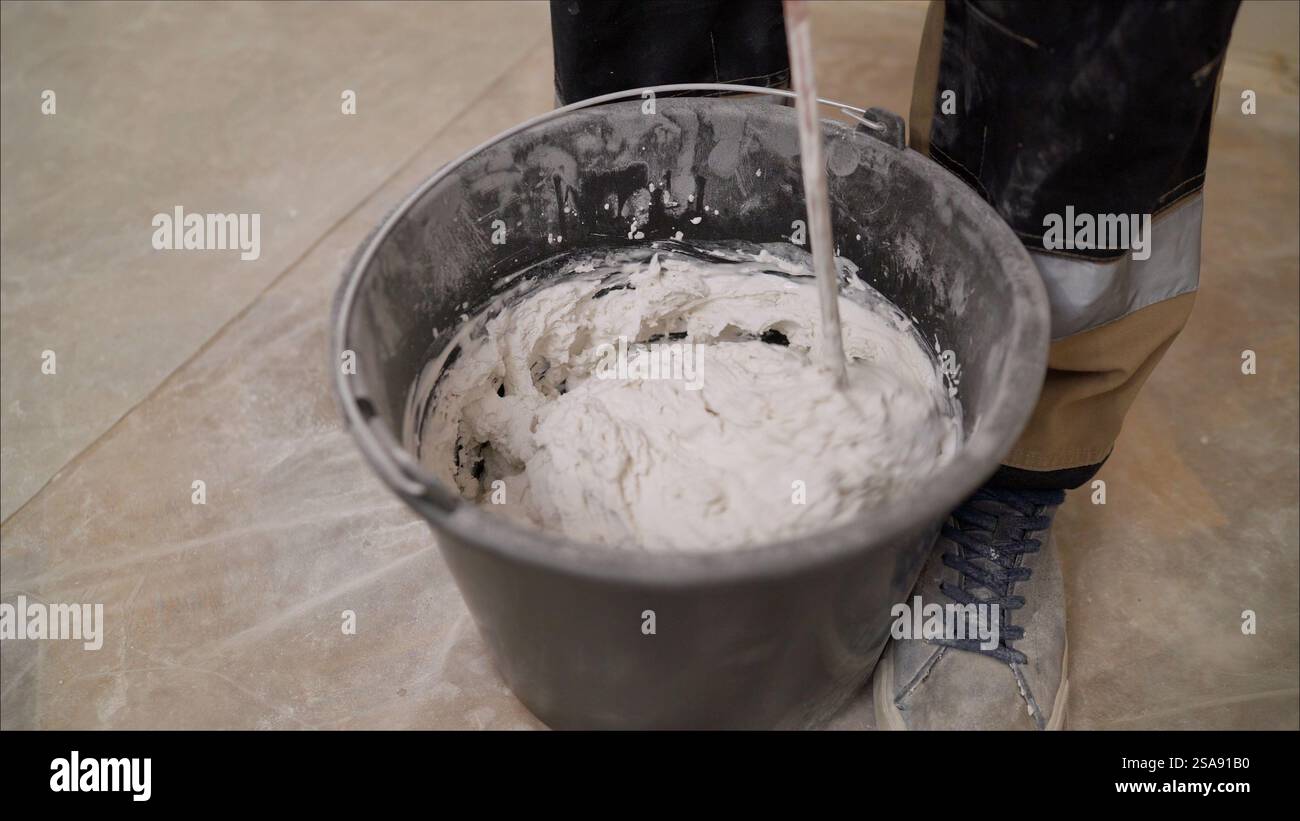 Close-up of construction materials mixing in a large bucket ...