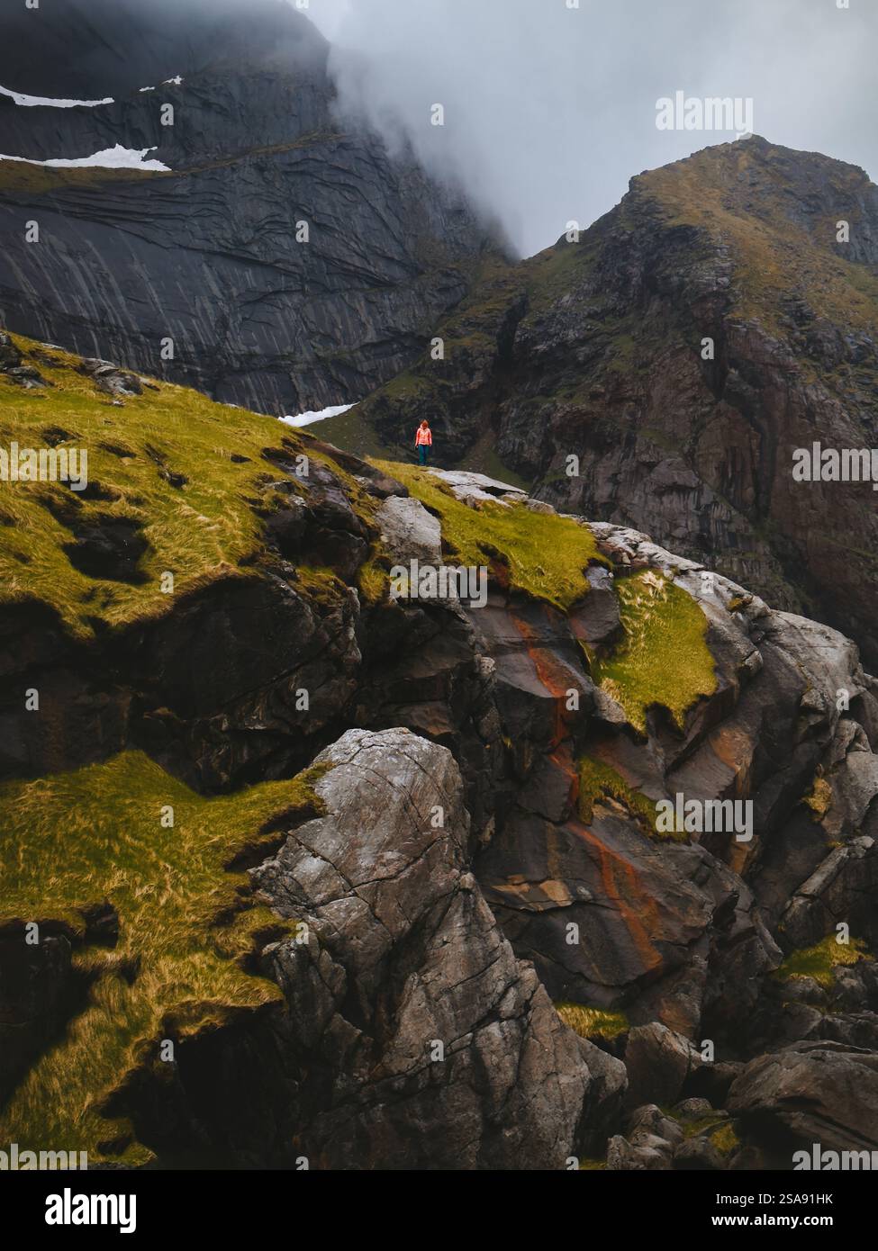 Foggy mountains rocks in northern Norway traveler on cliff, Lofoten ...
