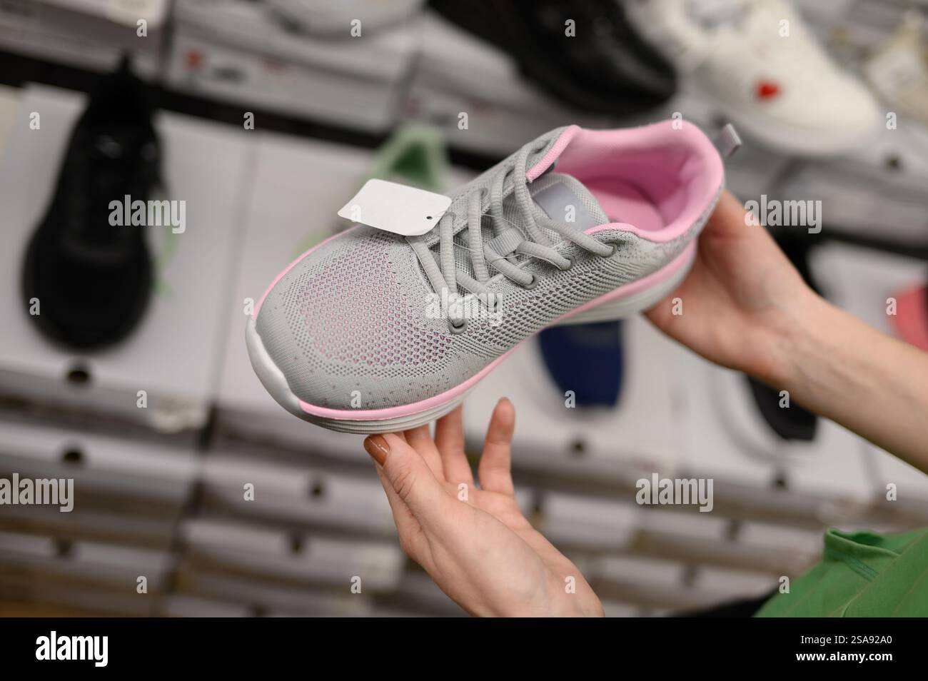 A woman chooses shoes in a shopping center in the sporting goods ...