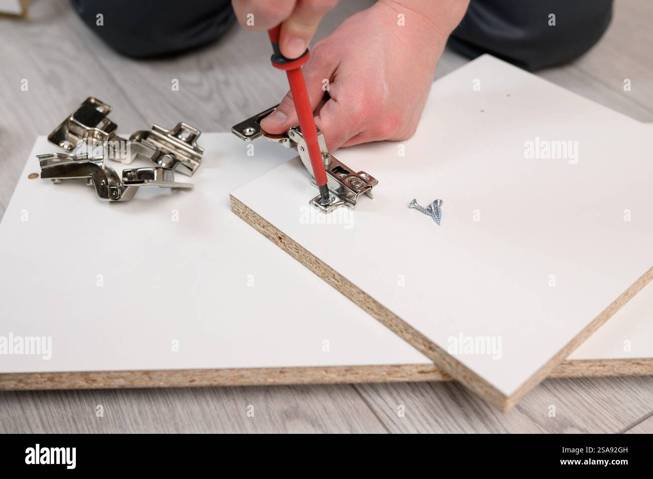 Furniture assembly. The worker inserts the loop and tightens it with a ...