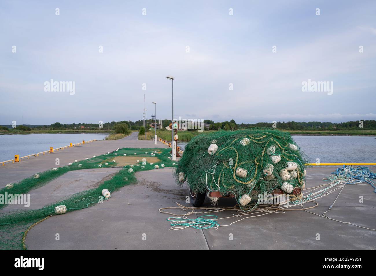 Fishing nets on the harbour quay. Heap of colourful trawling fishing ...