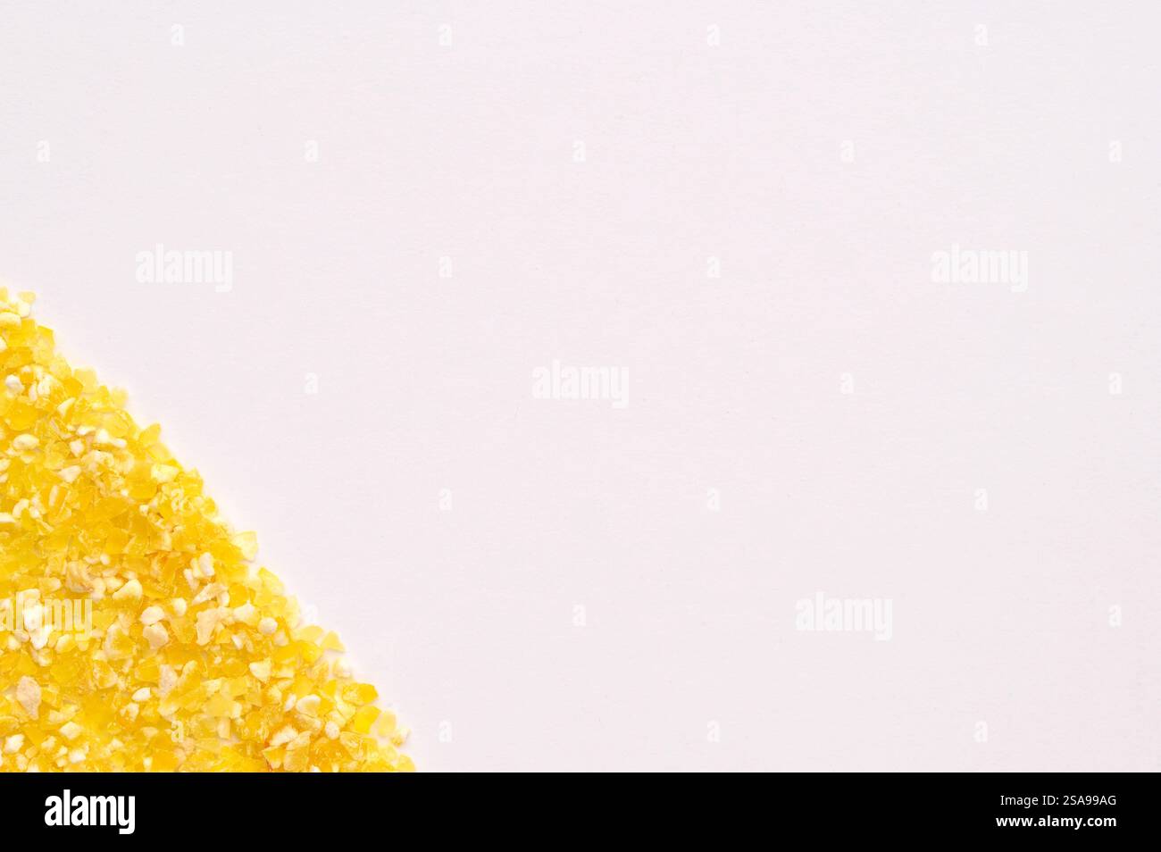 Macro photo of dry yellow corn porridge on a white background. Healthy ...