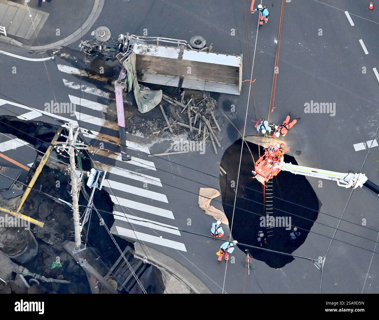 An aerial photo shows sinkholes at an intersection in Yashio City ...