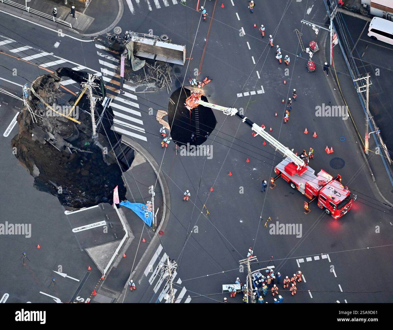 An aerial photo shows sinkholes at an intersection in Yashio City ...