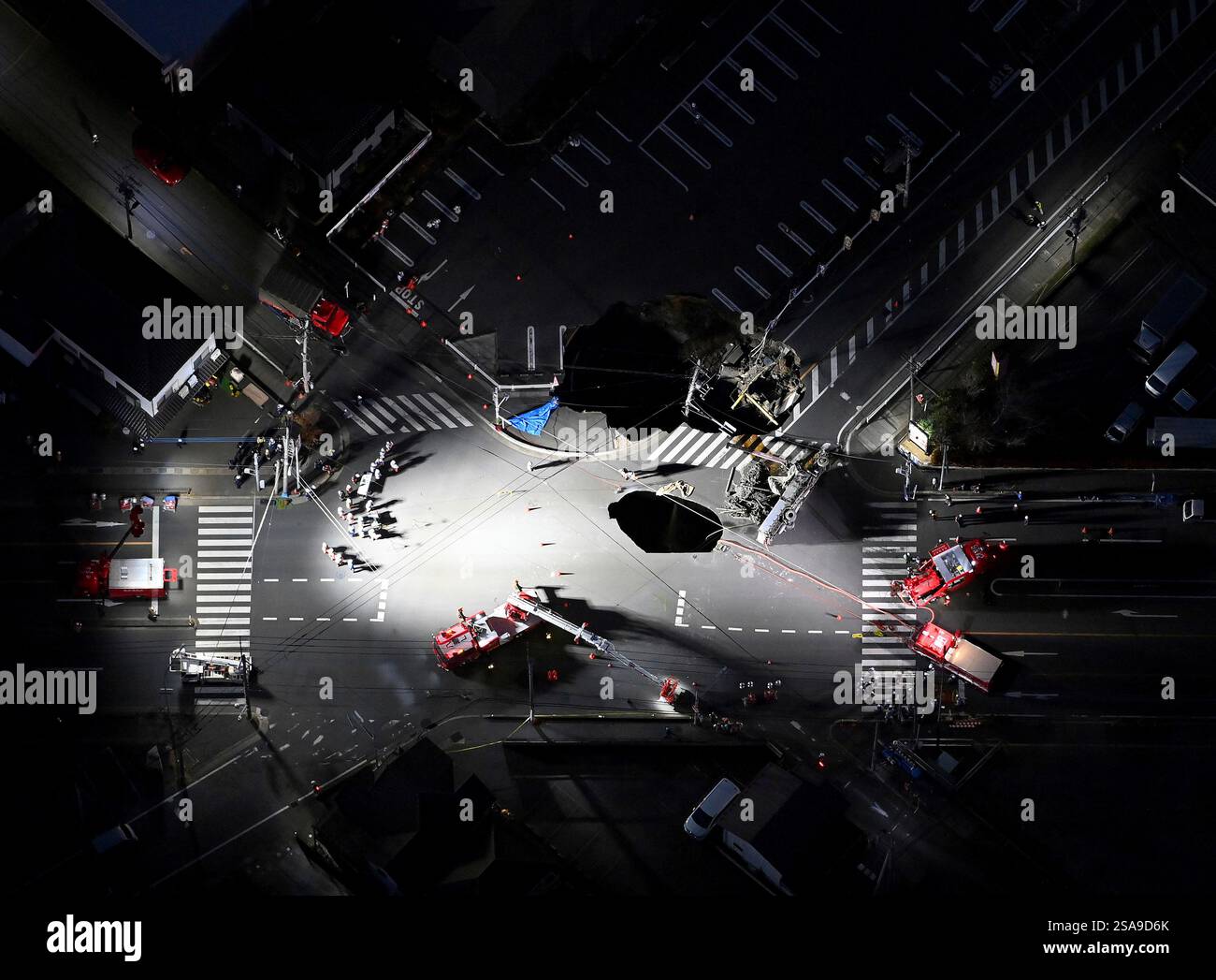 An aerial photo shows sinkholes at an intersection in Yashio City ...