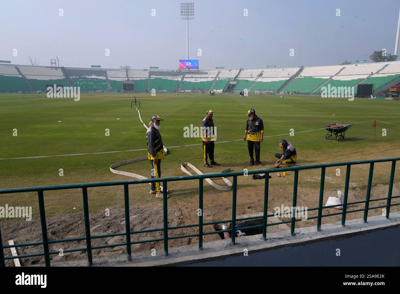 Groundsmen work at the Gaddafi Stadium, where renovation works are in ...