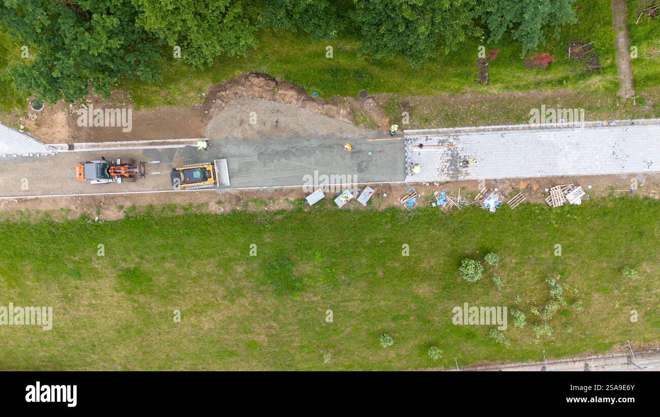 Aerial view of a pavement construction site with machinery and workers ...