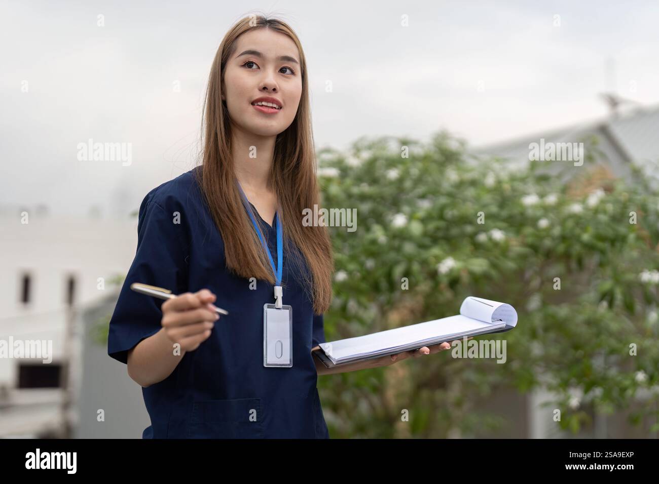 Nurse thoughtful healthcare professional taking notes outdoors Stock ...