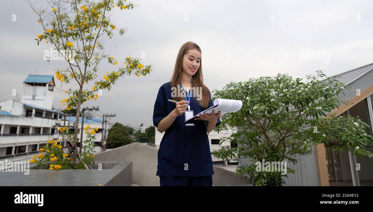 Healthcare professional reviewing patient records and notes outdoors ...