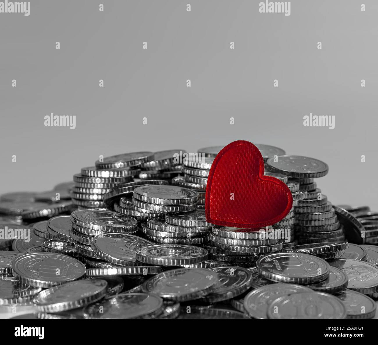 Red heart on a pile of shiny coins. Gray background. Valentine's Day ...