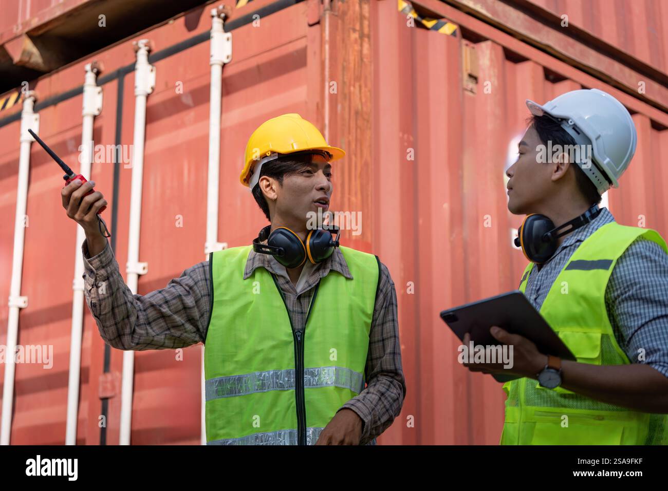 Logistics engineer discussing project details with a colleague in ...