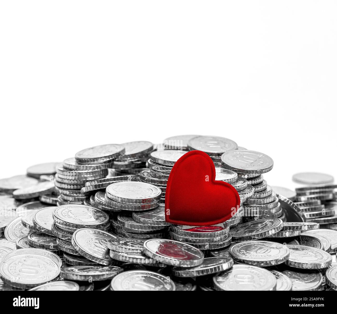 Red heart symbol on pile of silver coins. Donation, life saving or ...