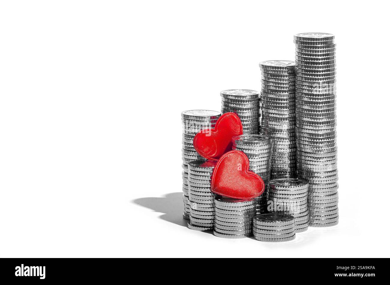 Columns of silver coins with two red hearts isolated on white. Concept ...
