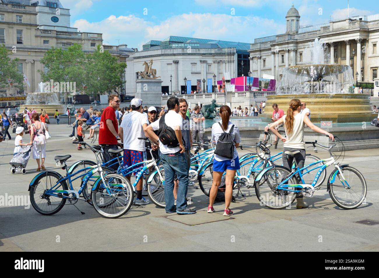 Tour guide leader talks to group men & women sightseeing tourists ...