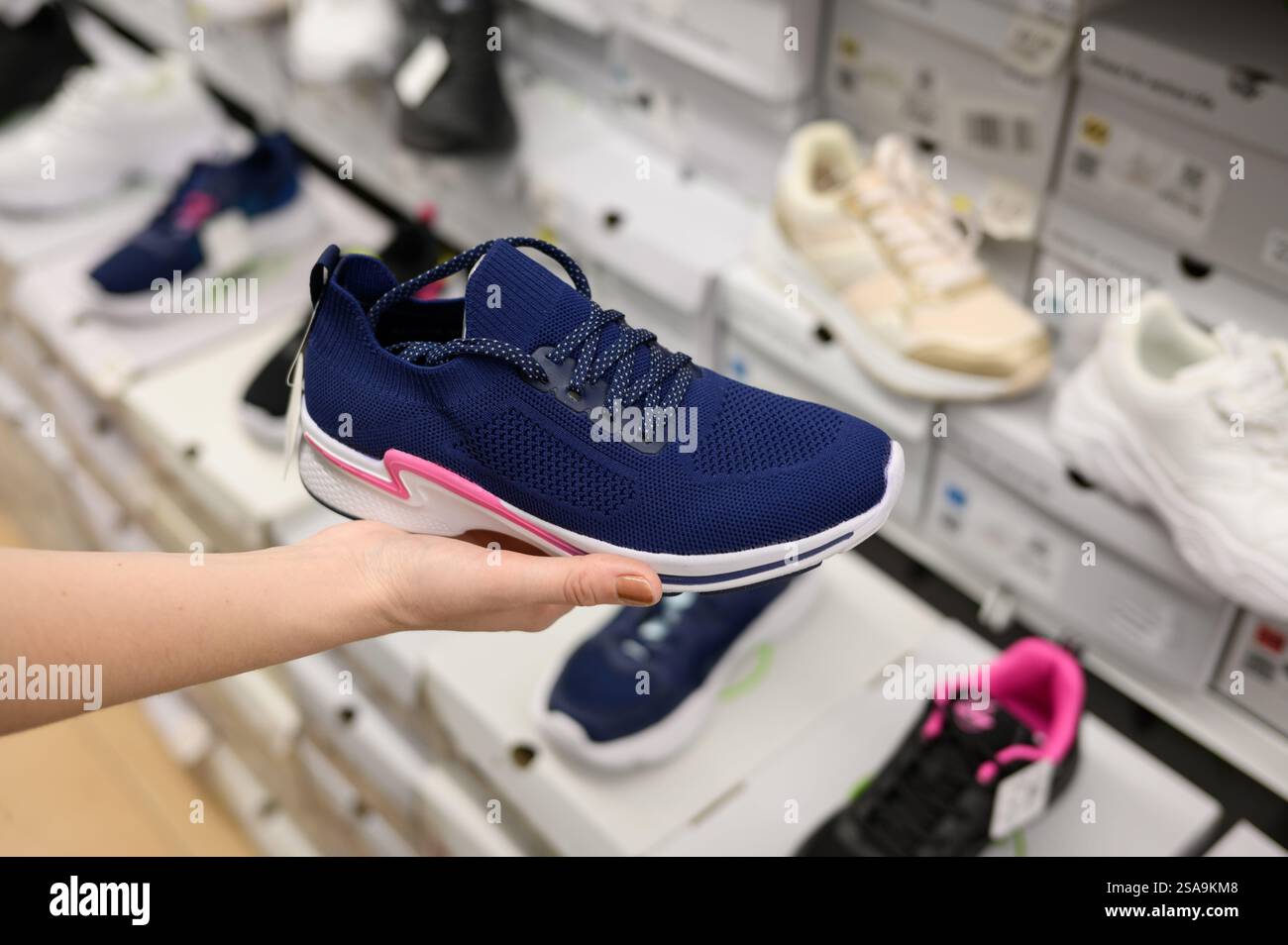 A woman chooses quality shoes in a shopping center in the sporting ...