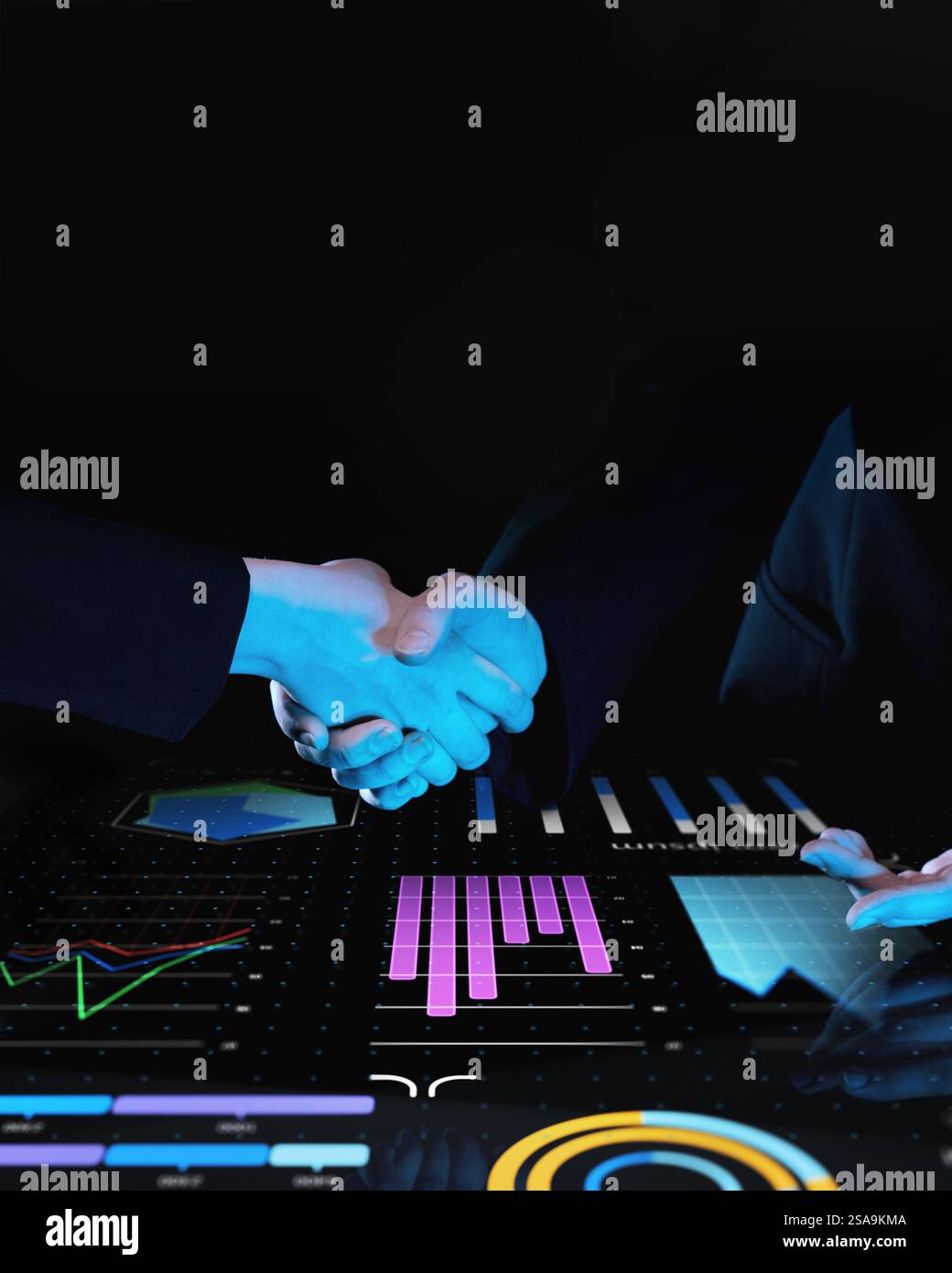 Business professionals shaking hands over interactive touch screen ...
