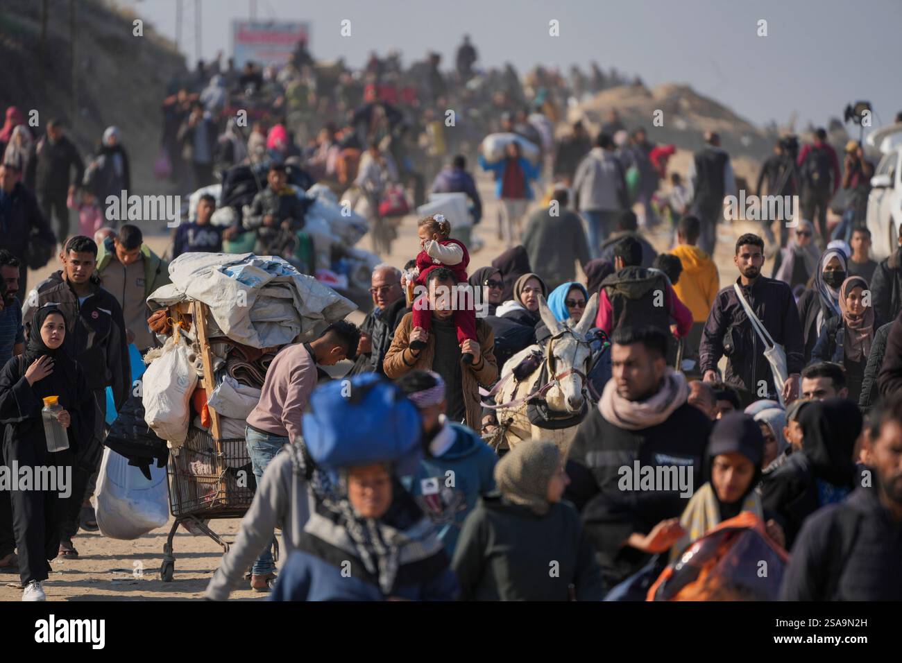 Displaced Palestinians walk on a road in central Gaza to return to ...