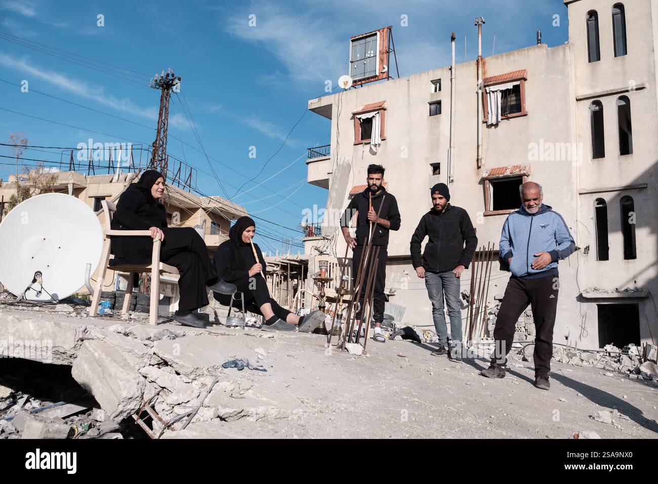 A family from the village of Bint Jbeil sitting on the roof of their ...