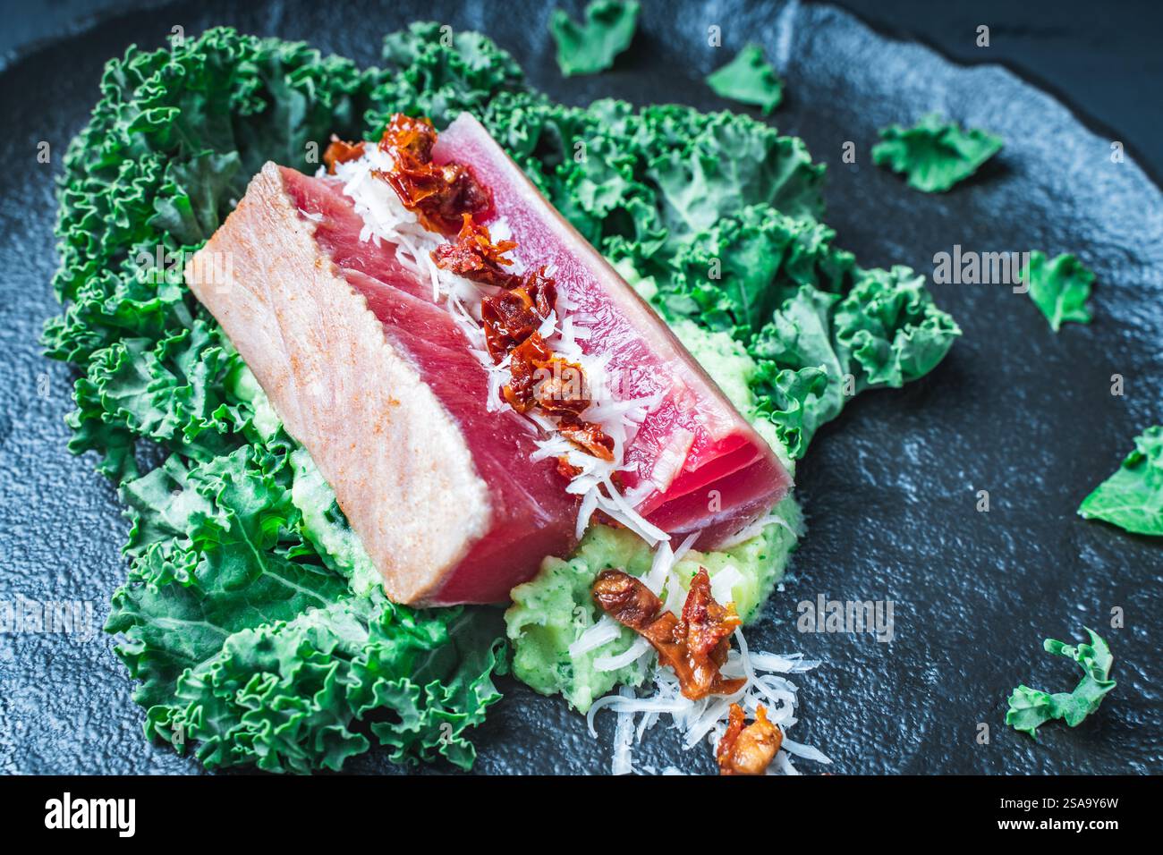 Tuna served with mashed potatoes, kale salad, sun-dried tomatoes and ...