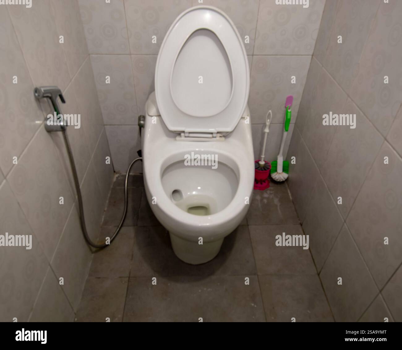 Photographed, wet and dirty toilet room with a set of white urinating ...