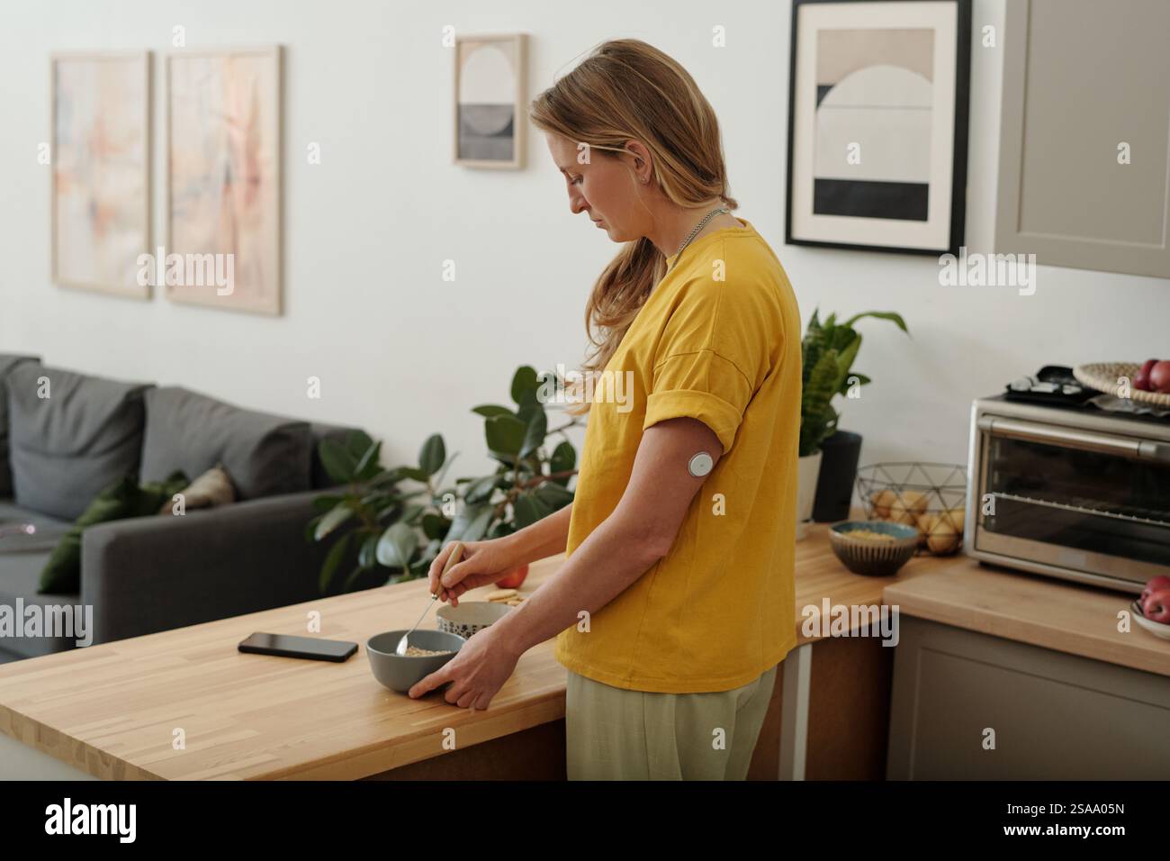 Back View Woman with Diabetes Making Breakfast with Focus on CGM Sensor ...