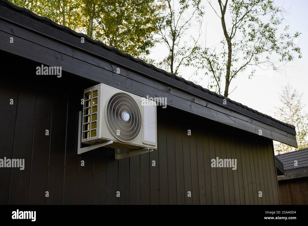 Outdoor air conditioner unit on wall of modern wooden house, farmstead ...