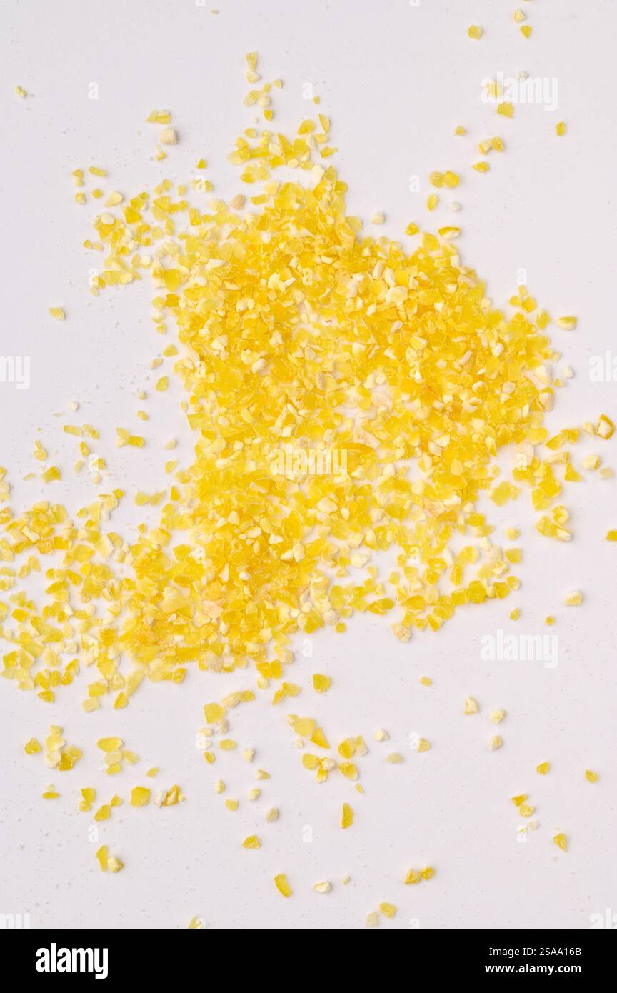 Macro photo of dry yellow corn porridge on a white background. Healthy ...