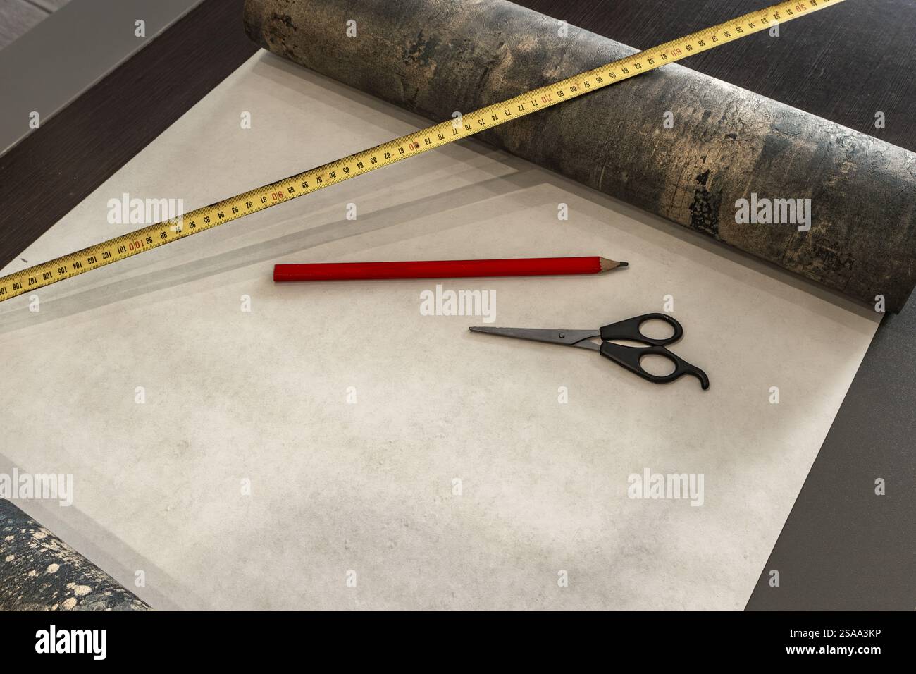 Cutting wallpaper before sticking it to the wall, scissors, measuring ...