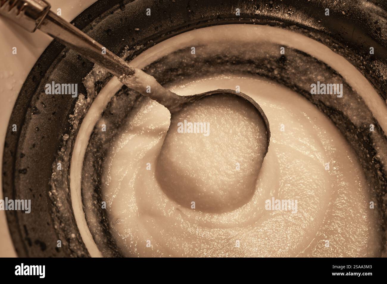 Mixing wallpaper glue in a bucket, a container with thick glue for ...